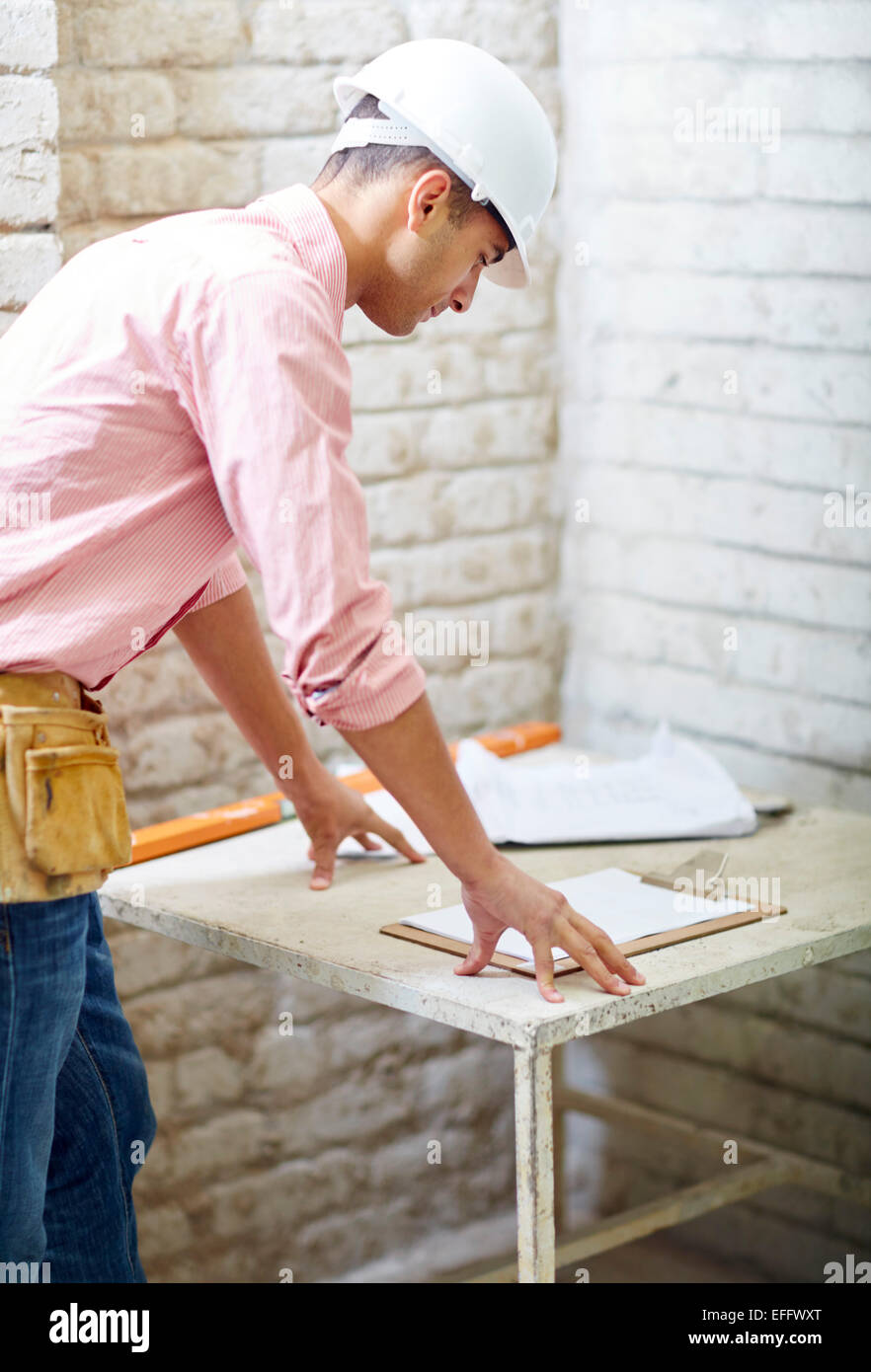 Foreman on construction site looking at building plan Stock Photo - Alamy