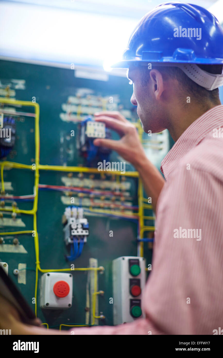 Electrician testing switch board Stock Photo - Alamy