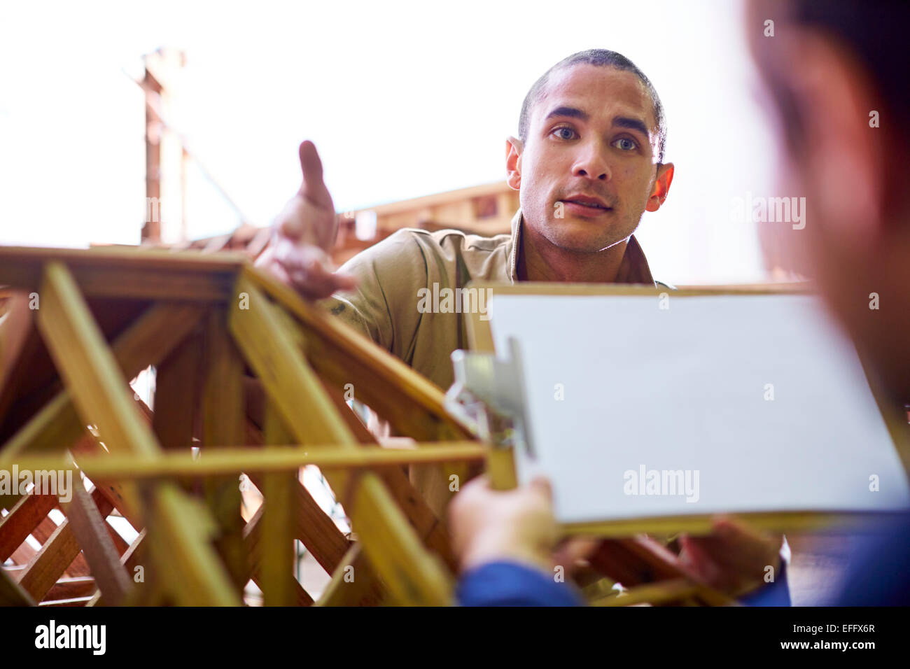Construction worker and foreman discussing roof beams Stock Photo - Alamy