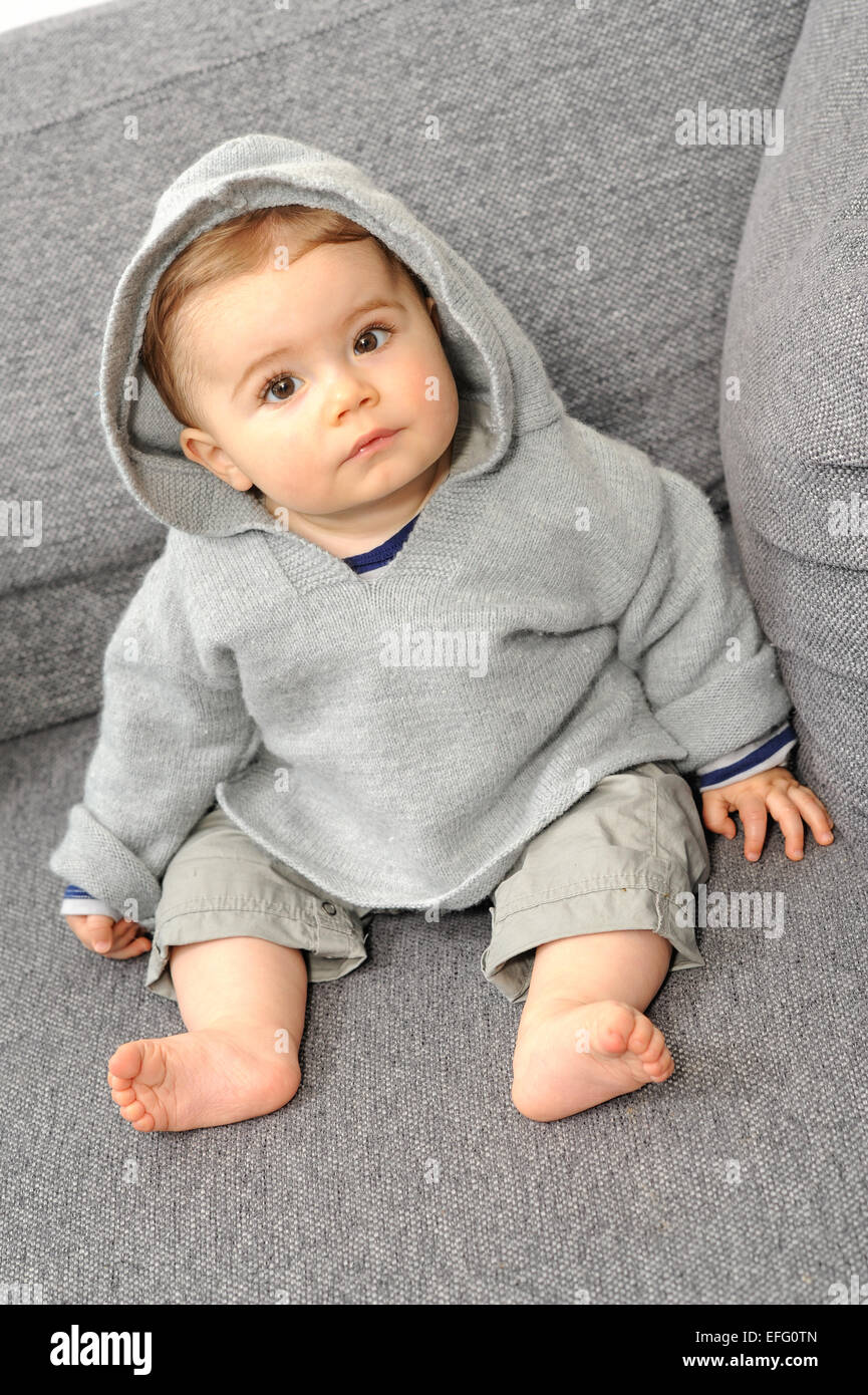 Small child - Baby sitting on sofa Stock Photo - Alamy