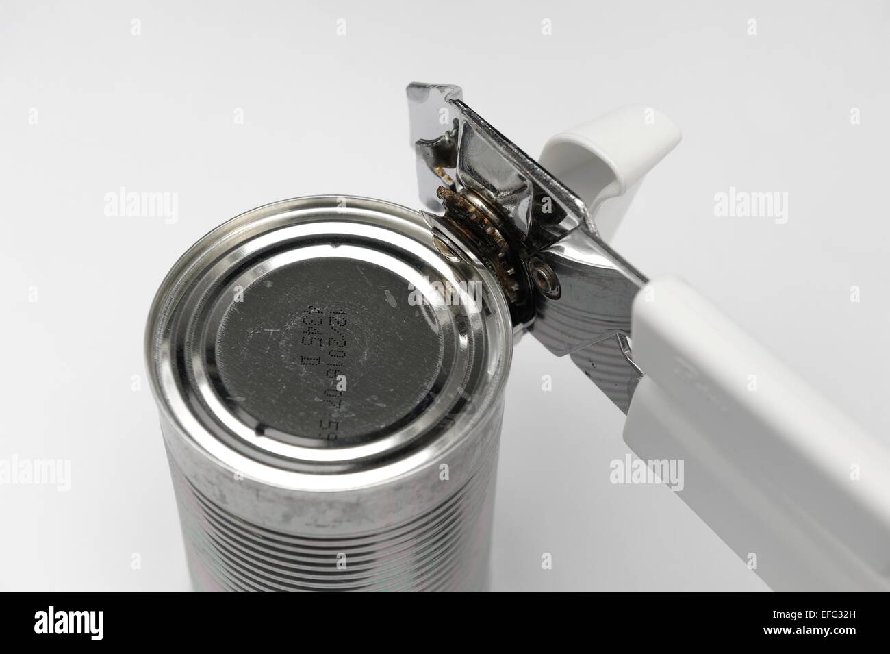 A tin can being opened with a hand can opener Stock Photo - Alamy