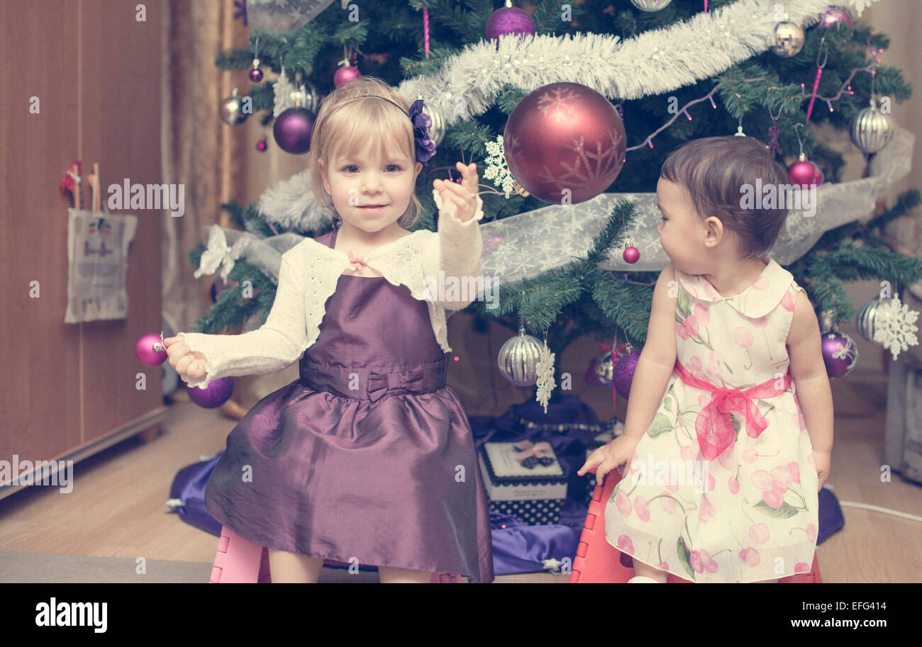 little girls near the Christmas tree Stock Photo - Alamy