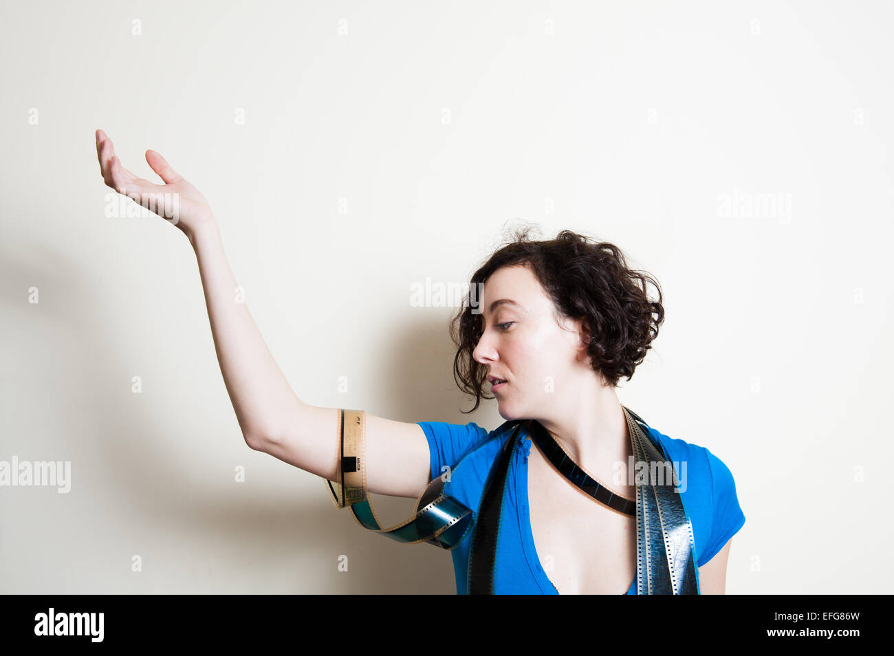 Young pretty woman relaxed expression and one hand up, with filmstrip ...
