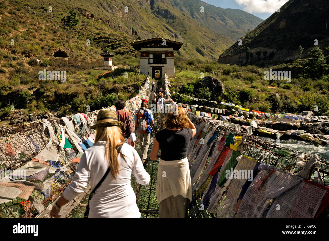 BHUTAN - Tour group and guide crossing a famous chain link bridge ...