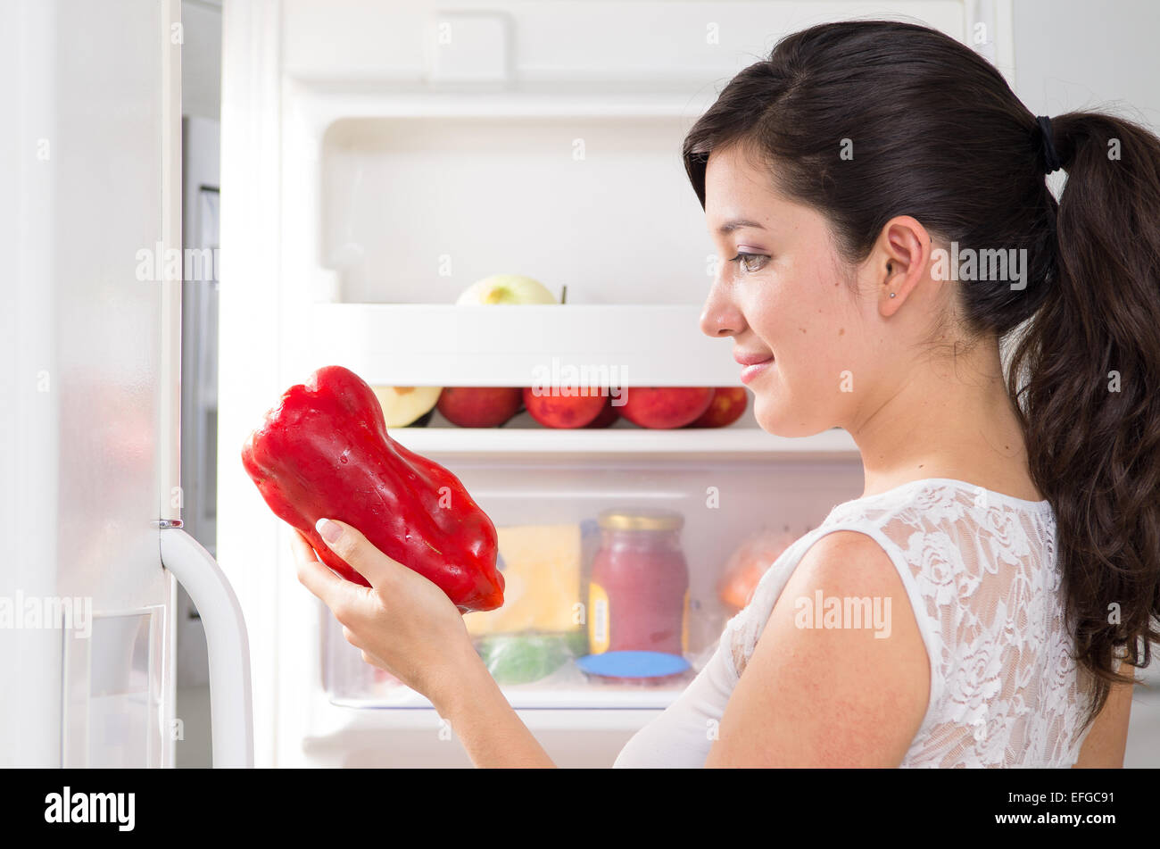 young beautiful woman searching for food in the fridge Stock Photo - Alamy