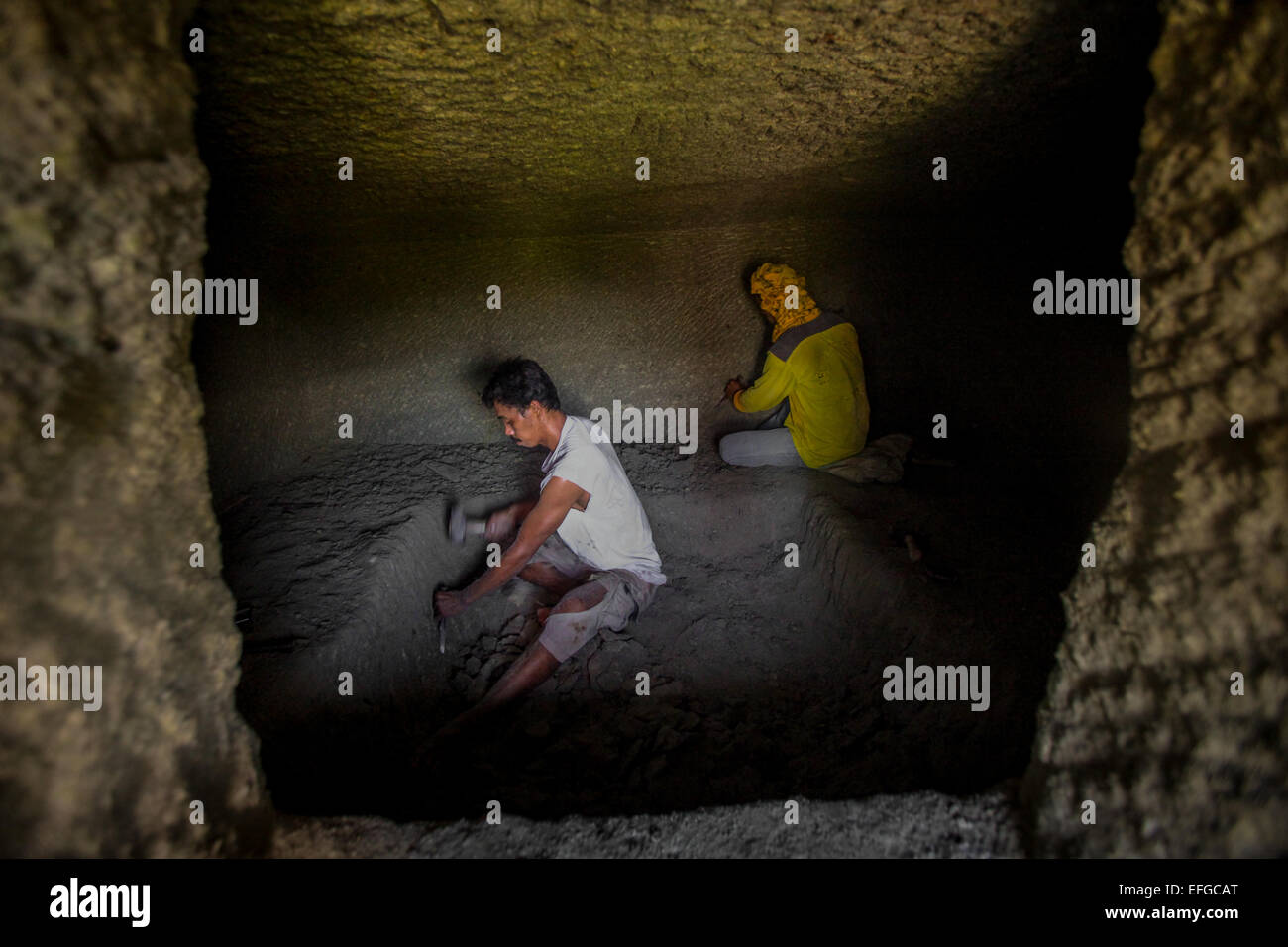 Workers digging and carving through rock to build a chamber for ...