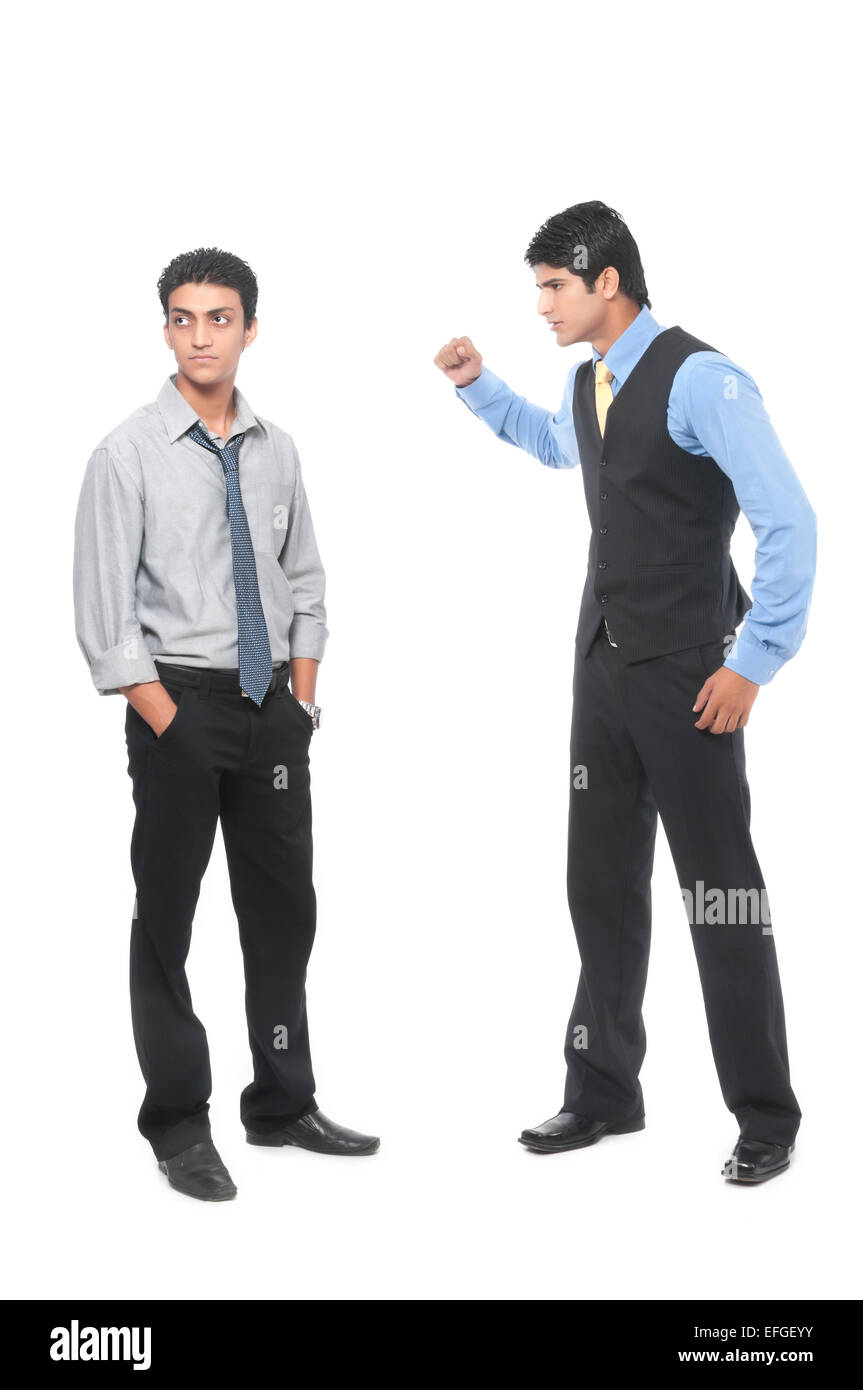 Two businessmen standing,one is trying to hit the other but the other ...