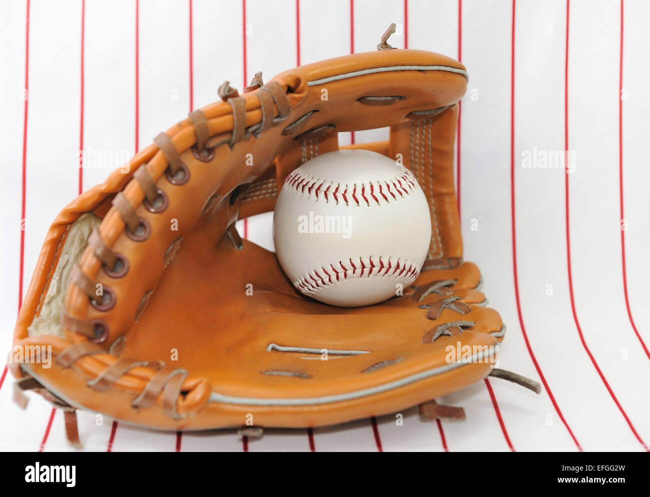 Baseball ball in a trap on a light striped background Stock Photo - Alamy