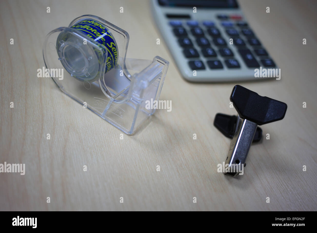 A roll of sellotape, a calculator and staple remover tool Stock Photo ...