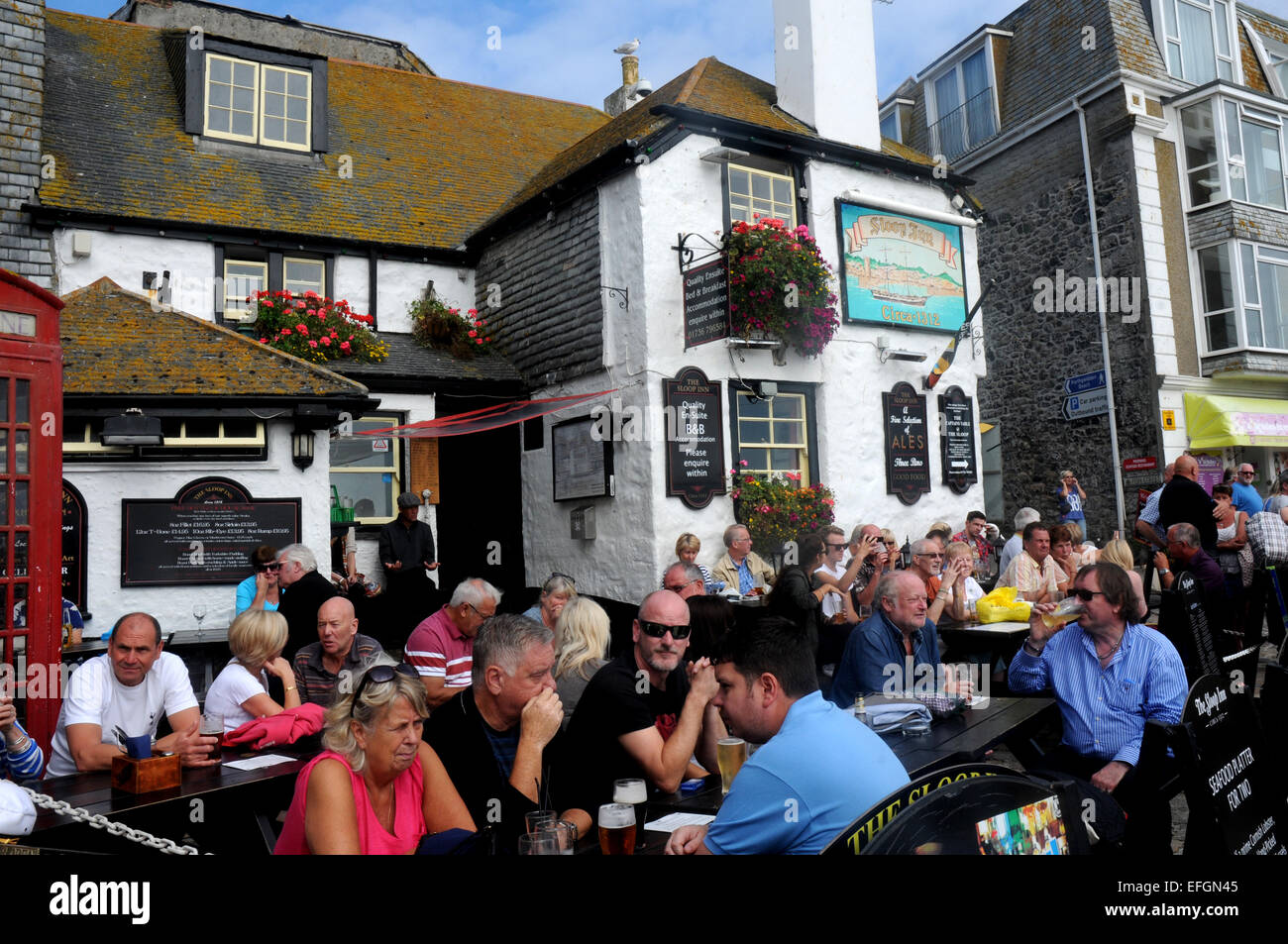 Enjoying the sunshine outside the Sloop Inn at St. Ives, Cornwall Stock ...