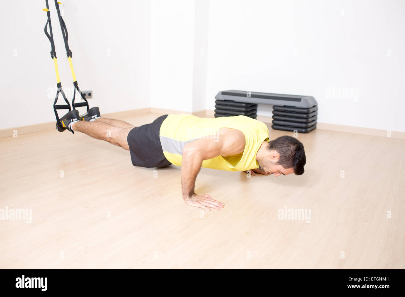 Athletic man makes TRX exercise Stock Photo - Alamy