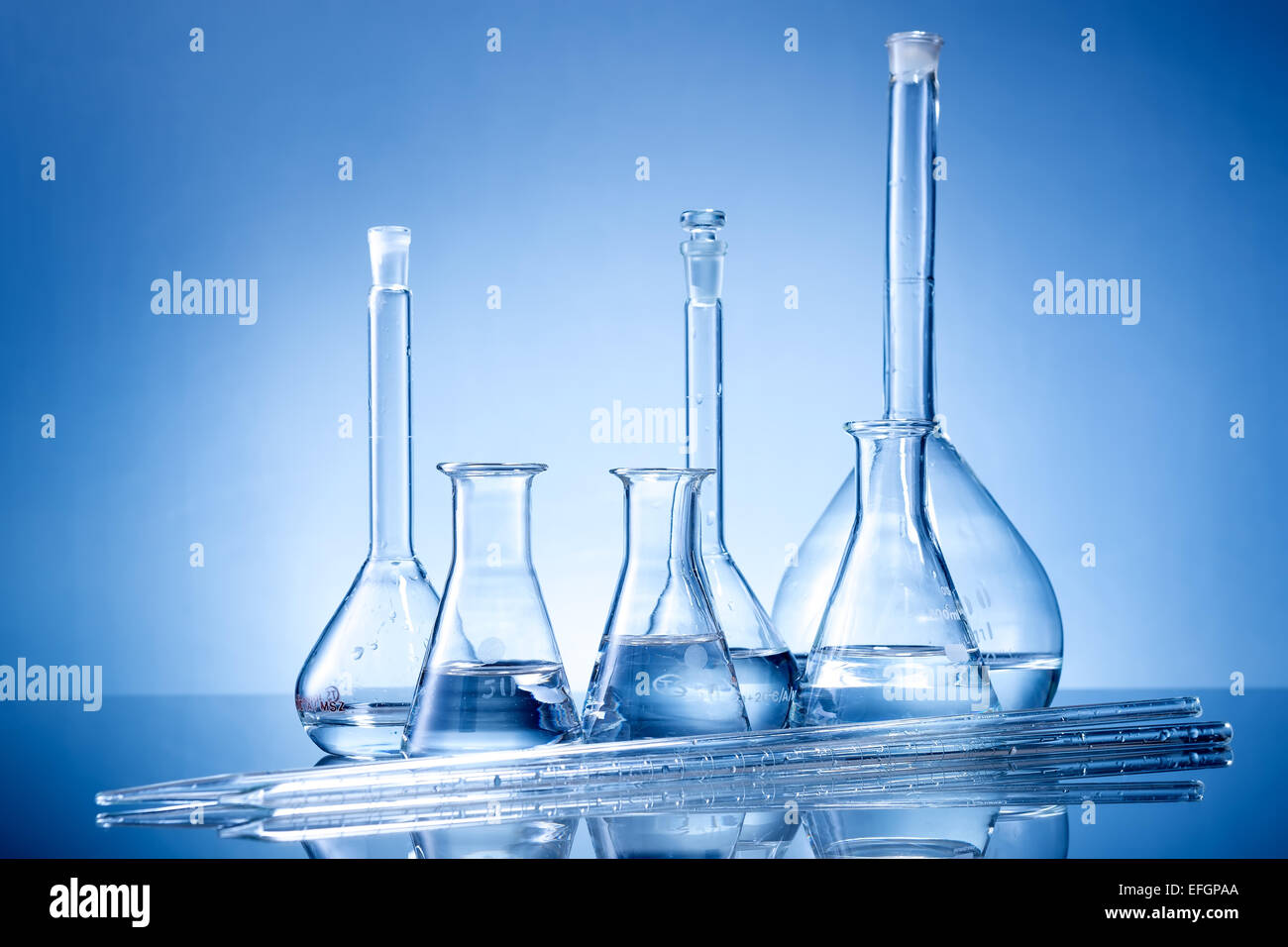 Laboratory equipment, glass flasks, pipettes on blue background Stock ...