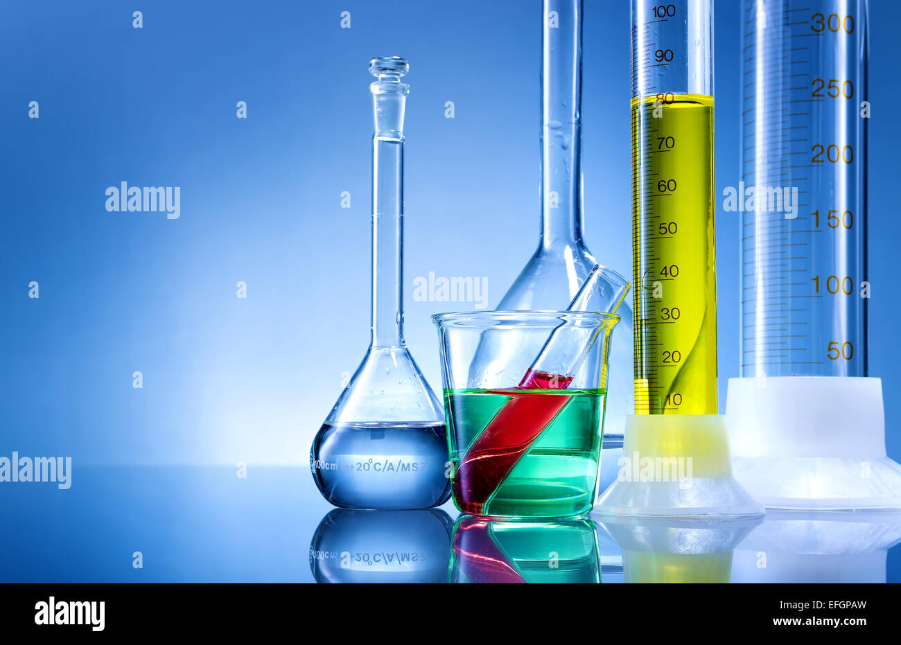 Laboratory equipment, bottles, flasks with color liquid on blue ...