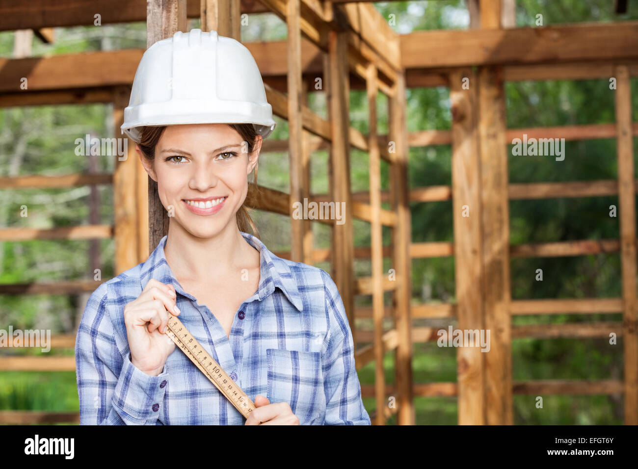 Happy Female Worker Holding Measuring Tape At Site Stock Photo - Alamy