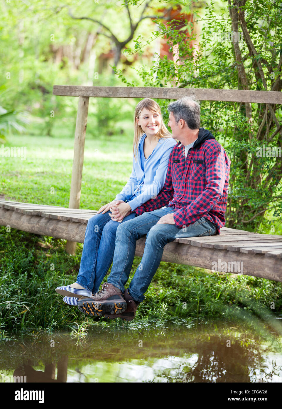 Woman sitting on wood bridge hi-res stock photography and images - Alamy