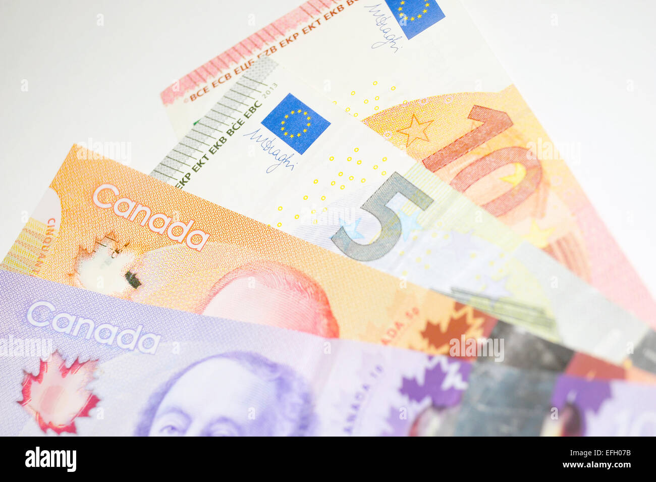 Canadian dollar notes and Euros photographed against a white background ...
