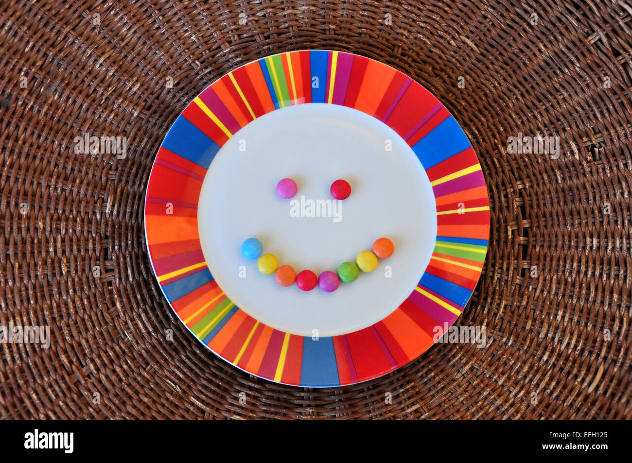 Plate with smiling face made from colorful candy. Abstract food ...
