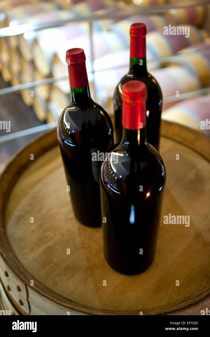 Three bottles of Bordeaux red wine on a barrel Stock Photo - Alamy