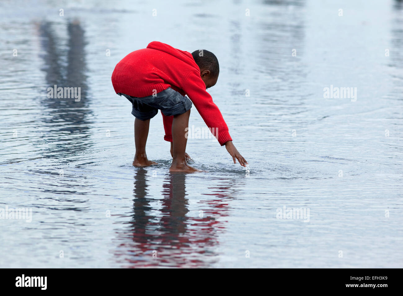 Child playing in a puddle Stock Photo - Alamy