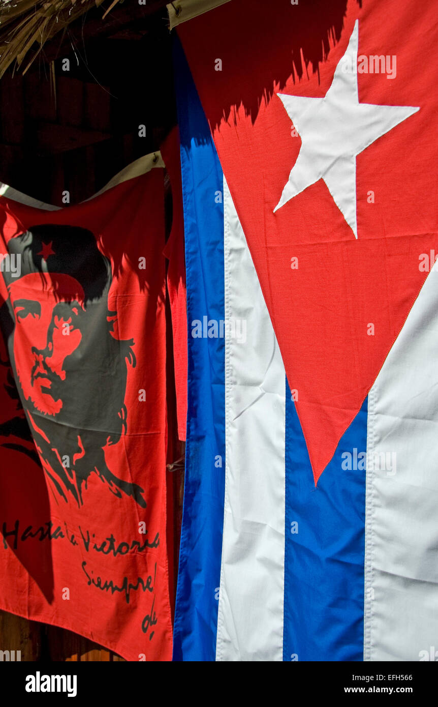 Vertical view of a Cuban flag and a Che Guevara flag hanging in the sun ...