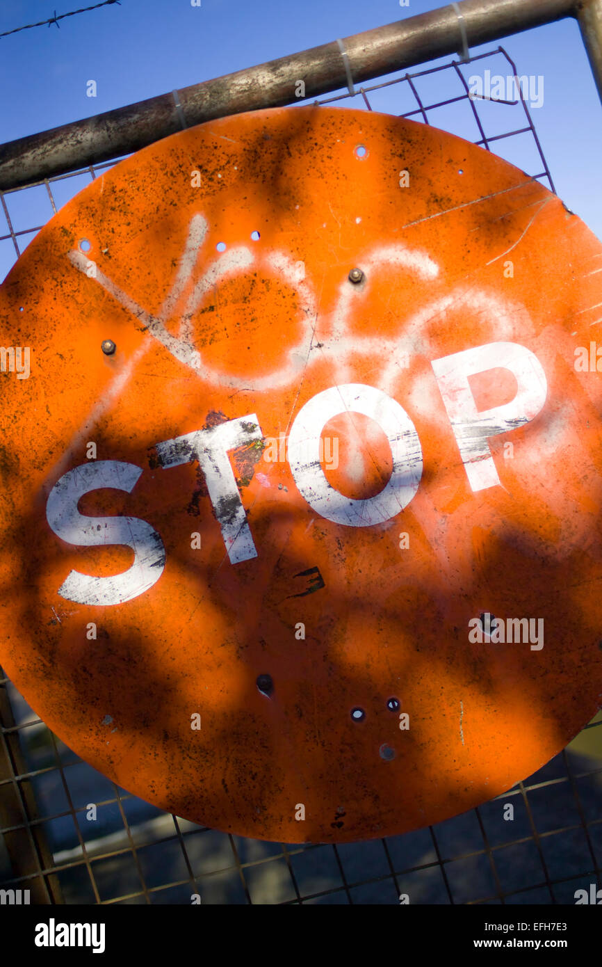 Round red stop sign with spray paint graffiti Stock Photo - Alamy