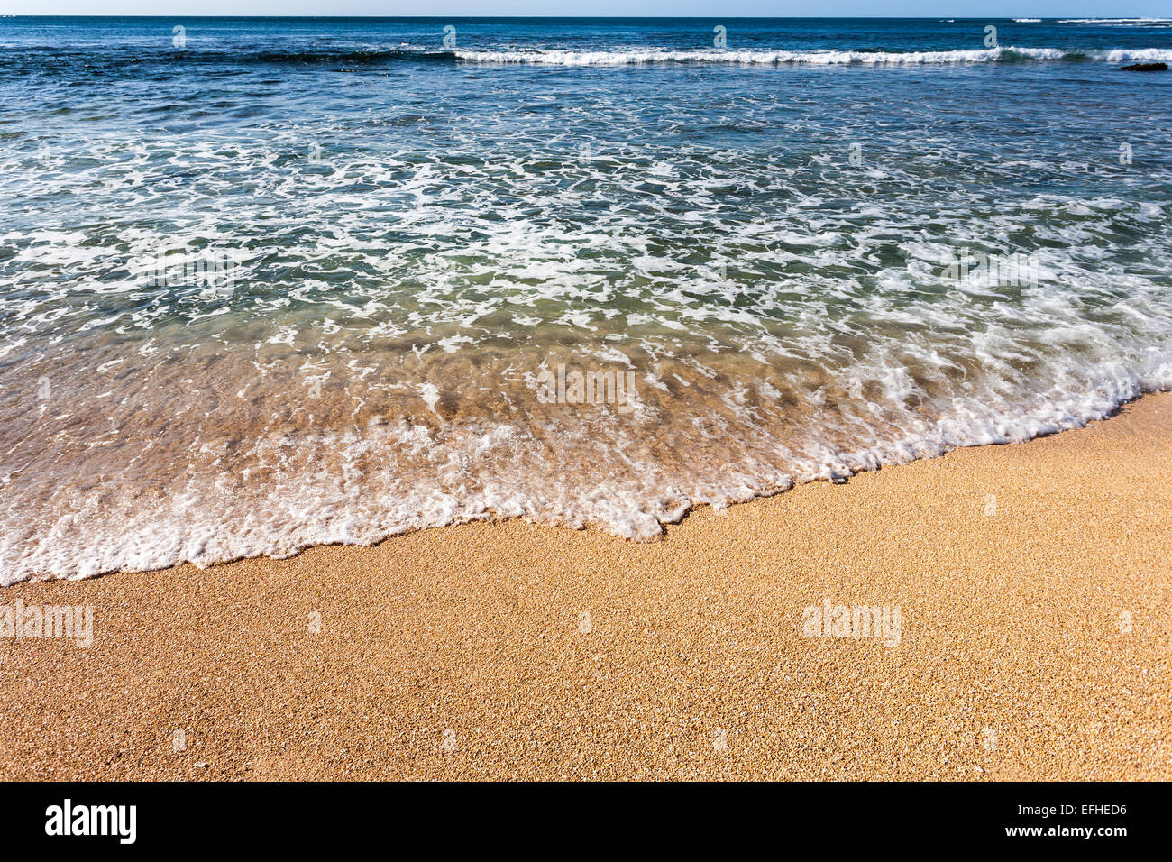 Tunnels Beach Calm Wave. A gentle wave washes up the rough sand at ...