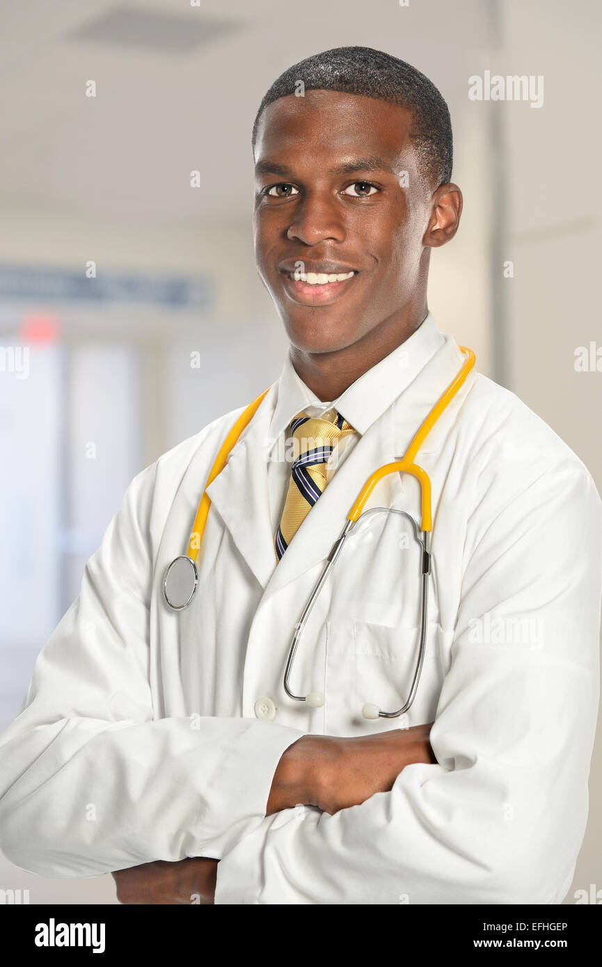 African American doctor smiling with arms crossed inside hospital Stock ...