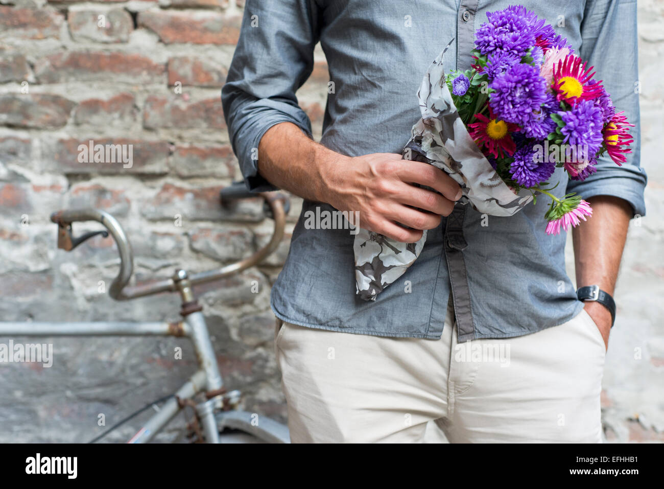 Casual young man stands with his back against a brick wall Stock Photo ...
