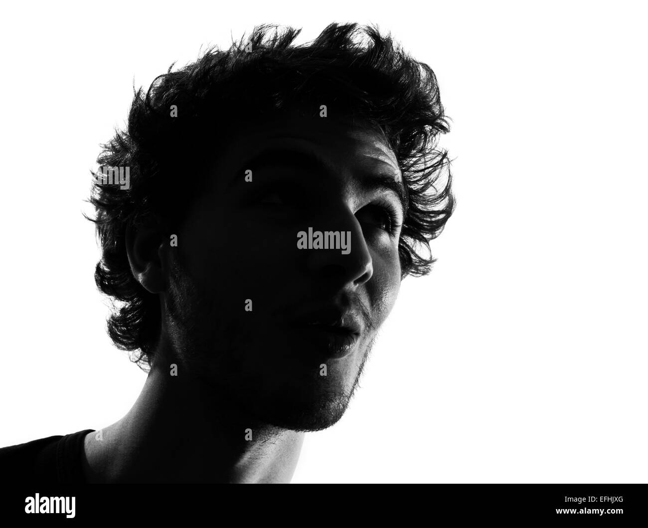 young man looking up portrait silhouette in studio isolated on white ...