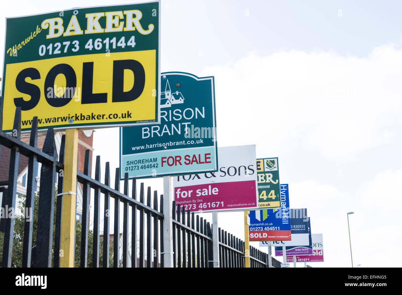 lots of estate agent boards for sale, sold, to let boards all lined up ...