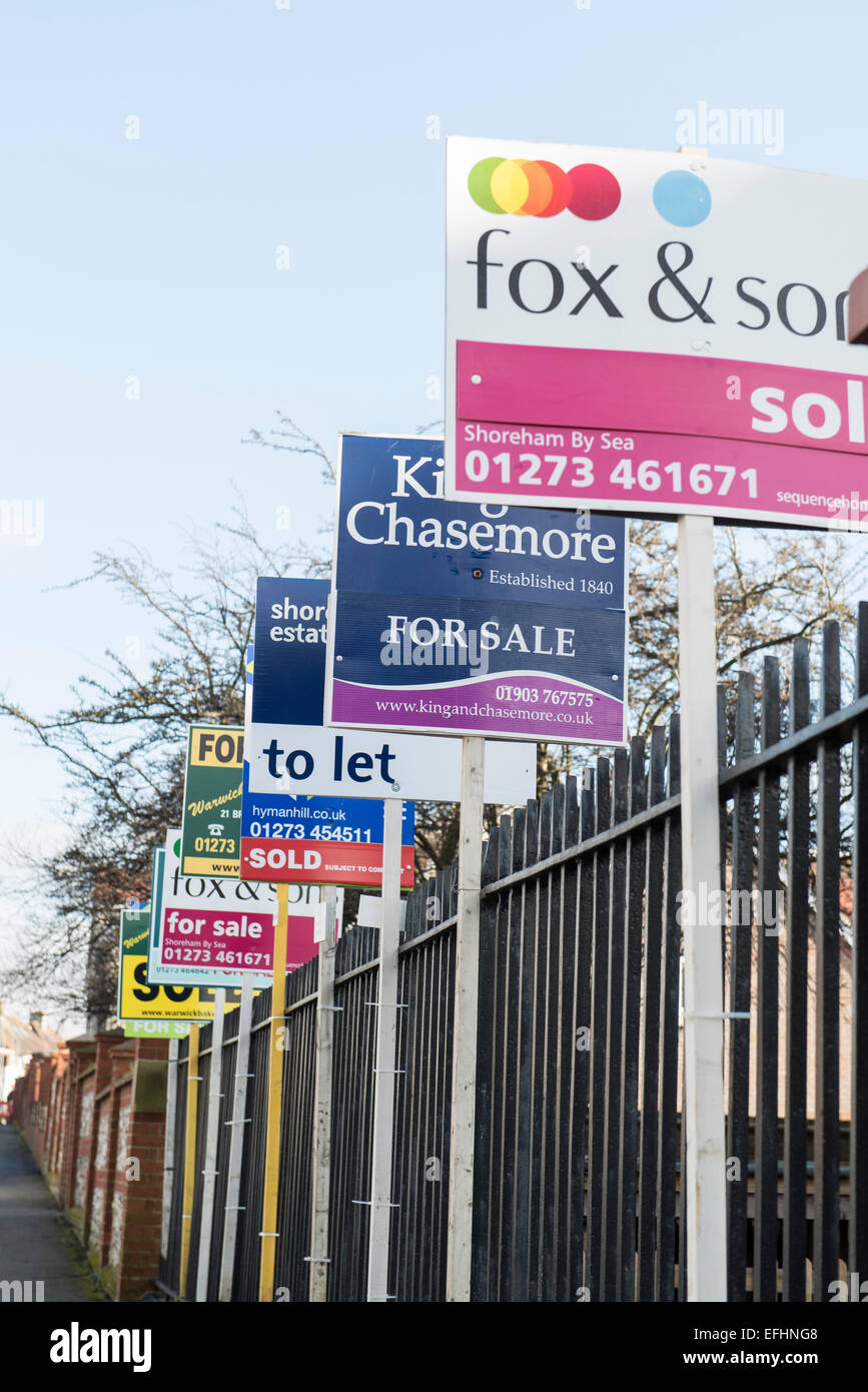 lots of estate agent boards for sale, sold, to let boards all lined up ...