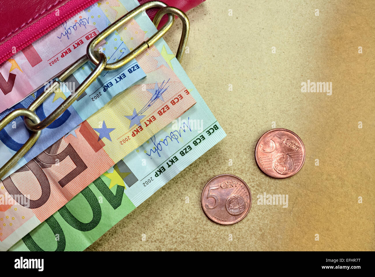Money in a red chained wallet on yellow background Stock Photo - Alamy
