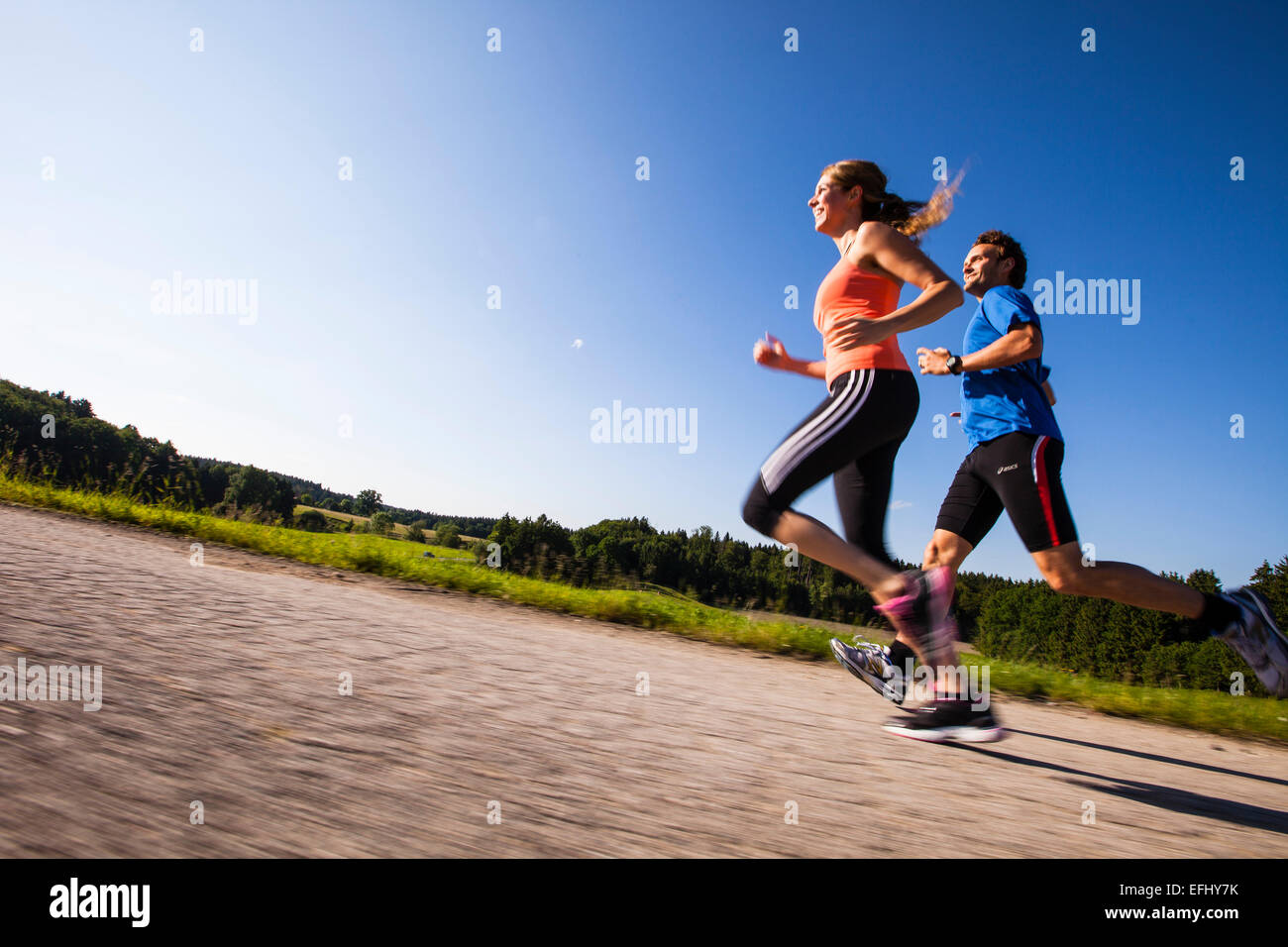 Two women running along road hi-res stock photography and images - Alamy