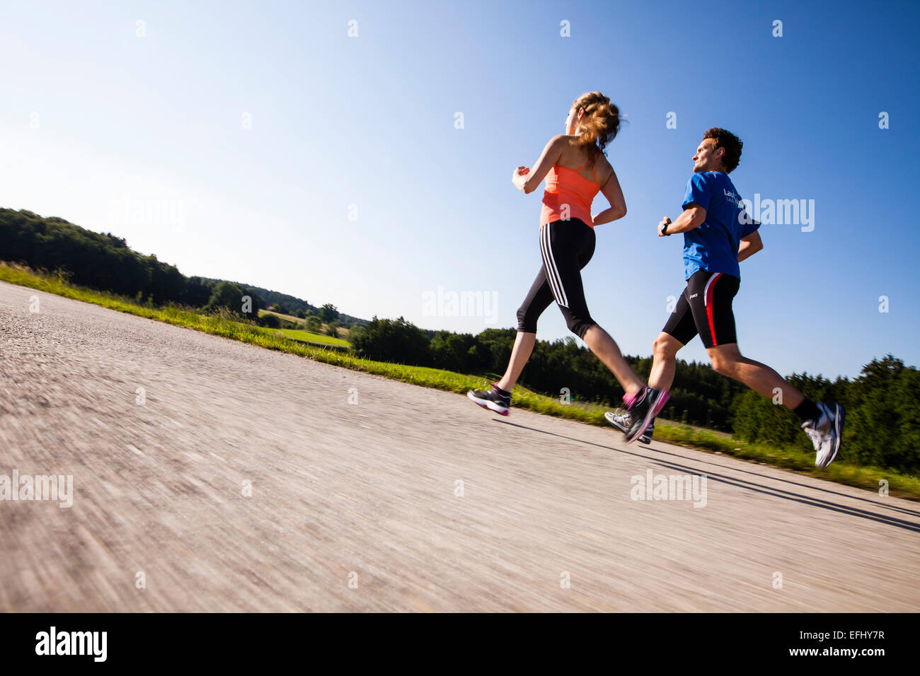 Two women running along road hi-res stock photography and images - Alamy