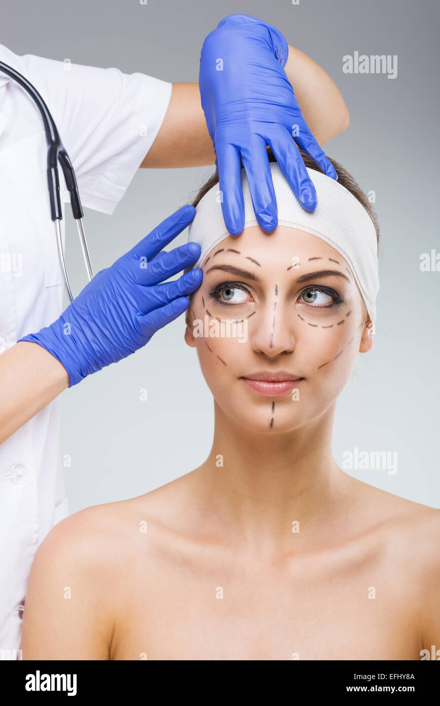 Beautiful woman with plastic surgery, drawn, plastic surgeon hands ...