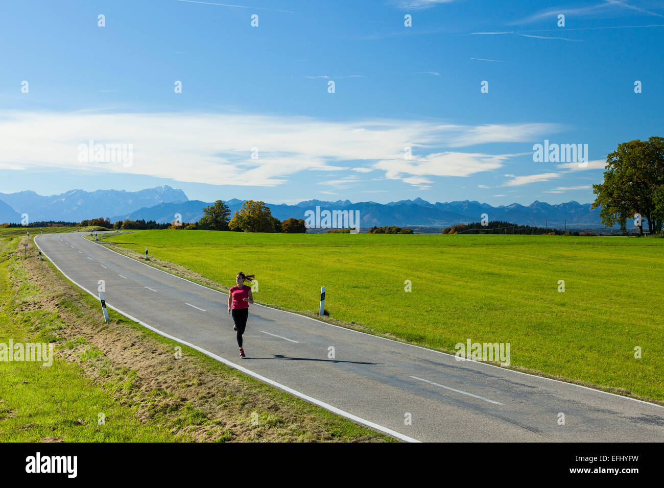 Woman jogging along a road, Munsing, Bavaria, Germany Stock Photo - Alamy
