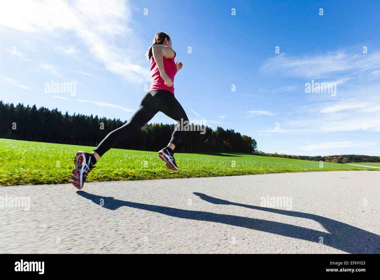 Woman jogging along a road, Munsing, Bavaria, Germany Stock Photo - Alamy