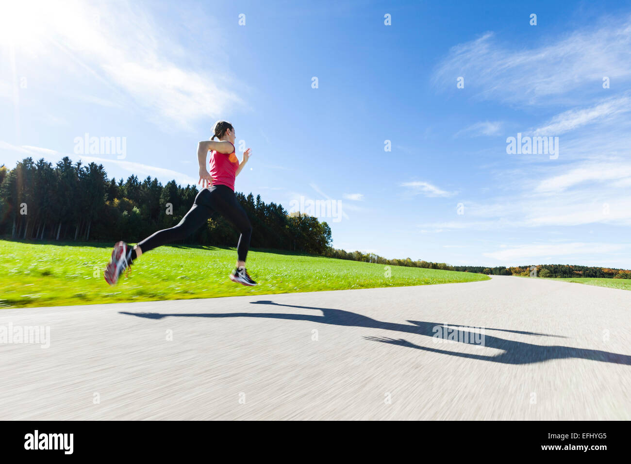 Woman jogging along a road, Munsing, Bavaria, Germany Stock Photo - Alamy