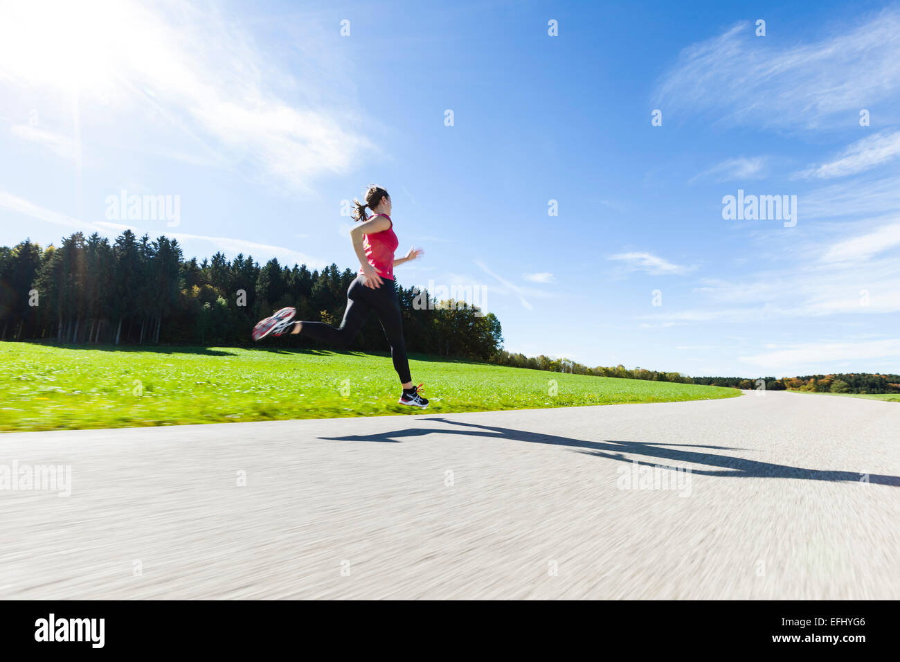Woman jogging along a road, Munsing, Bavaria, Germany Stock Photo - Alamy