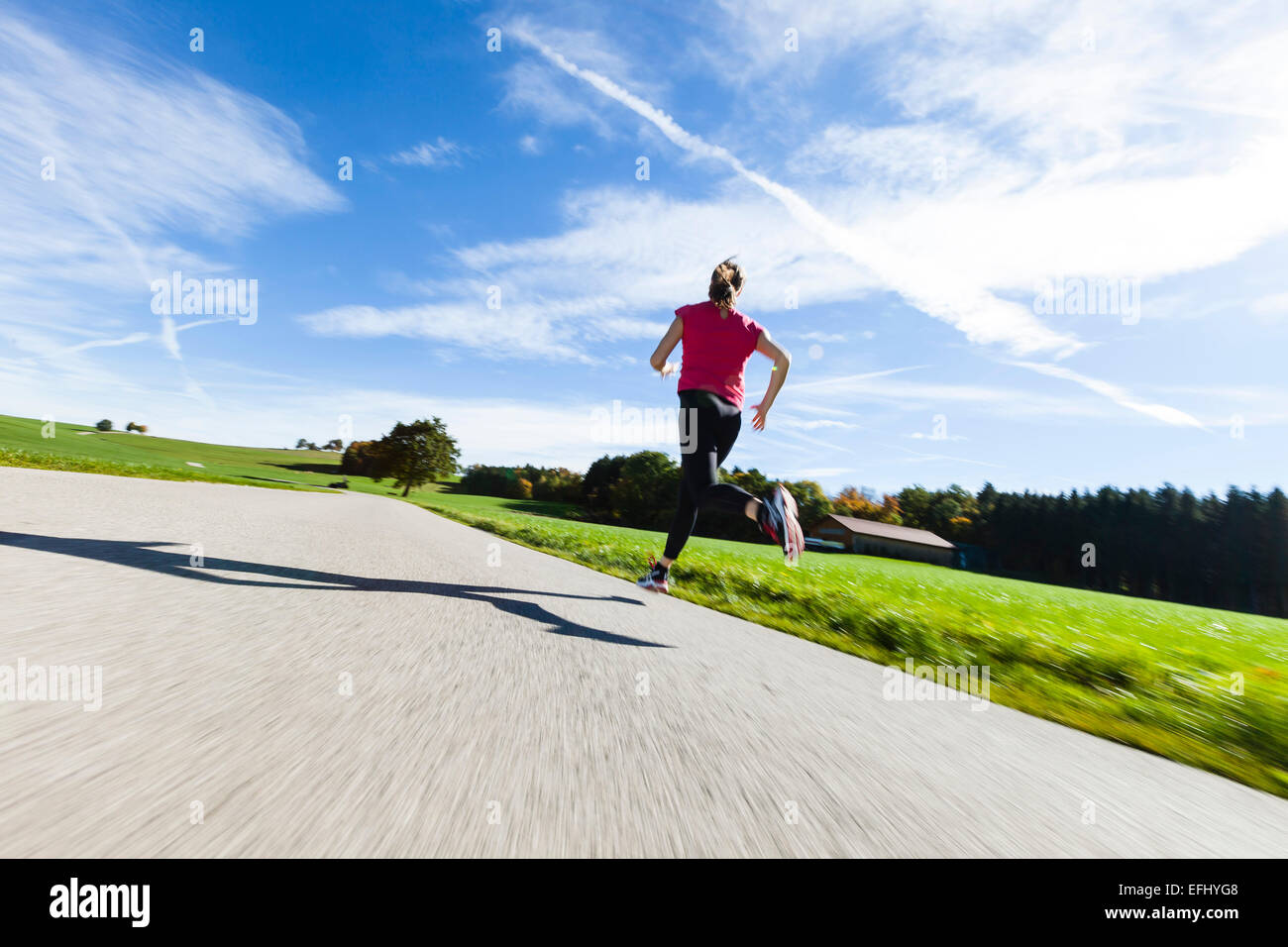 Woman jogging along a road, Munsing, Bavaria, Germany Stock Photo - Alamy