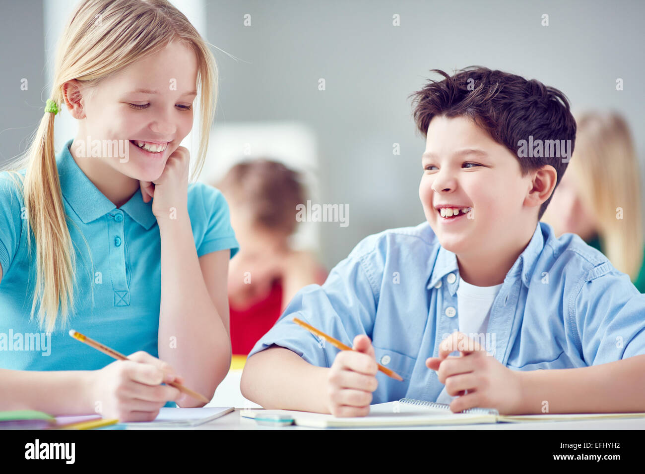 Happy elementary learners interacting at lesson Stock Photo - Alamy