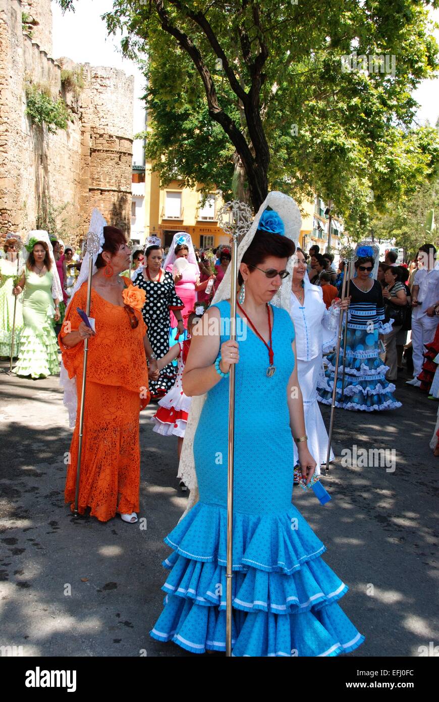 Spanish women in traditional dresses walking through the street during ...