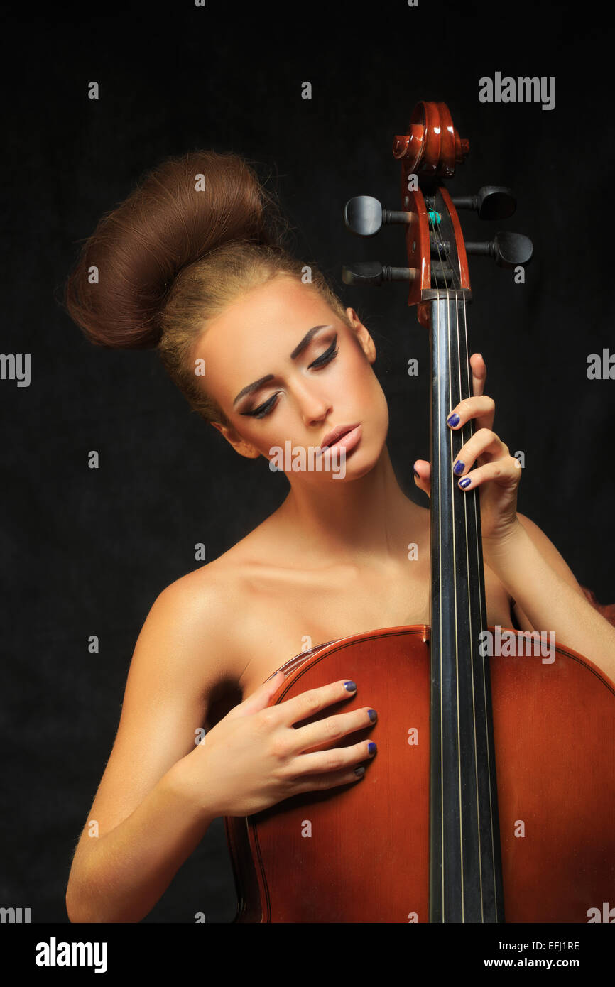 golden beautiful female musician playing a cello Stock Photo - Alamy