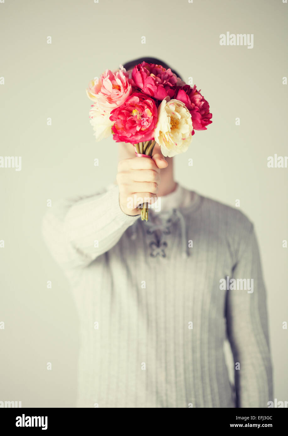 man covering his face with bouquet of flowers Stock Photo - Alamy