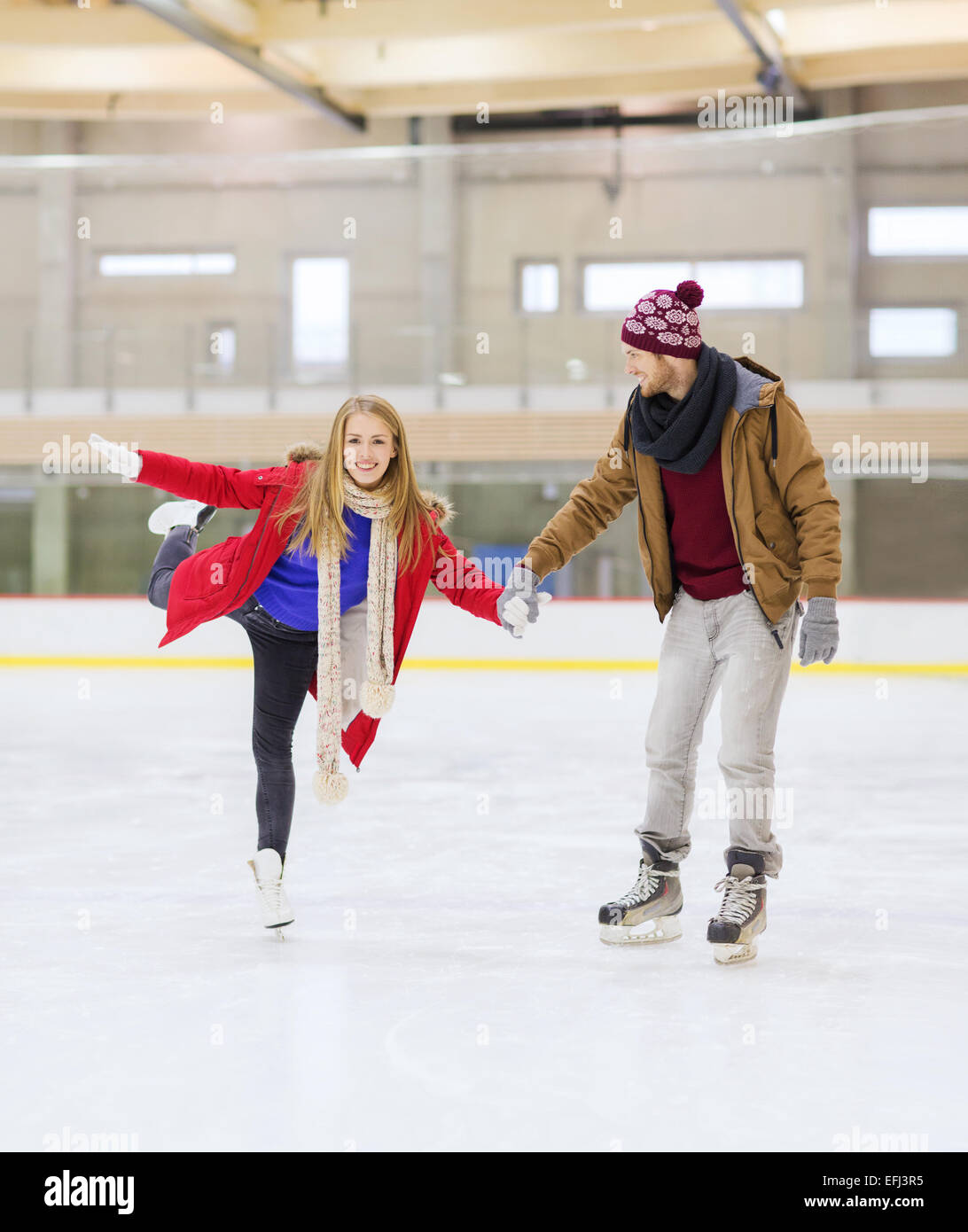 happy couple holding hands on skating rink Stock Photo - Alamy