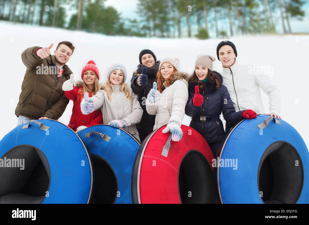 group of smiling friends with snow tubes Stock Photo - Alamy