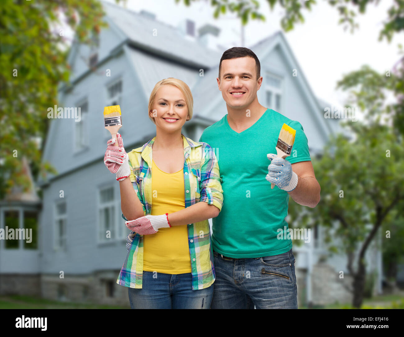 repair, building and home concept - smiling couple smearing wallpaper ...