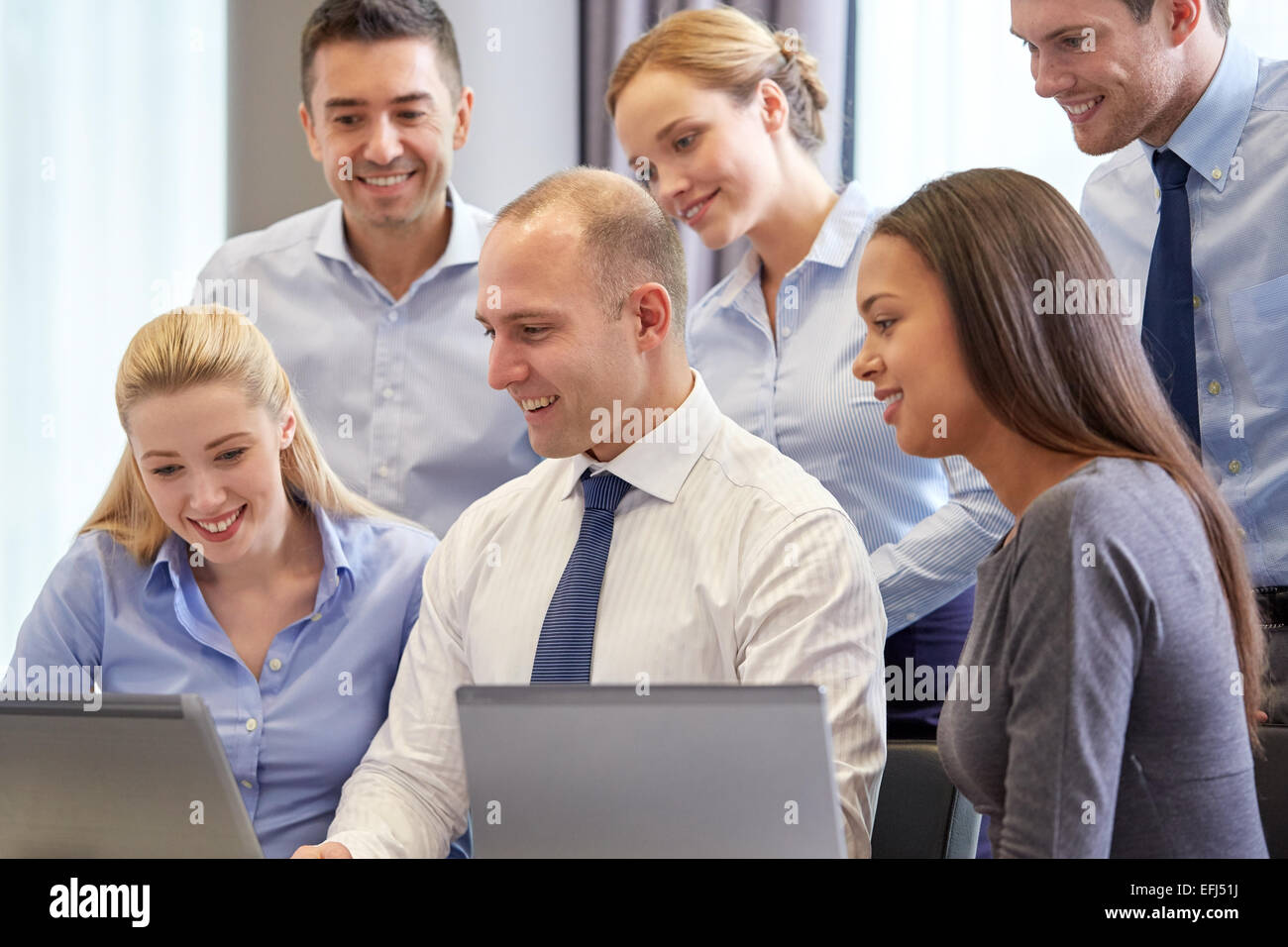 smiling business people with laptop computer Stock Photo - Alamy