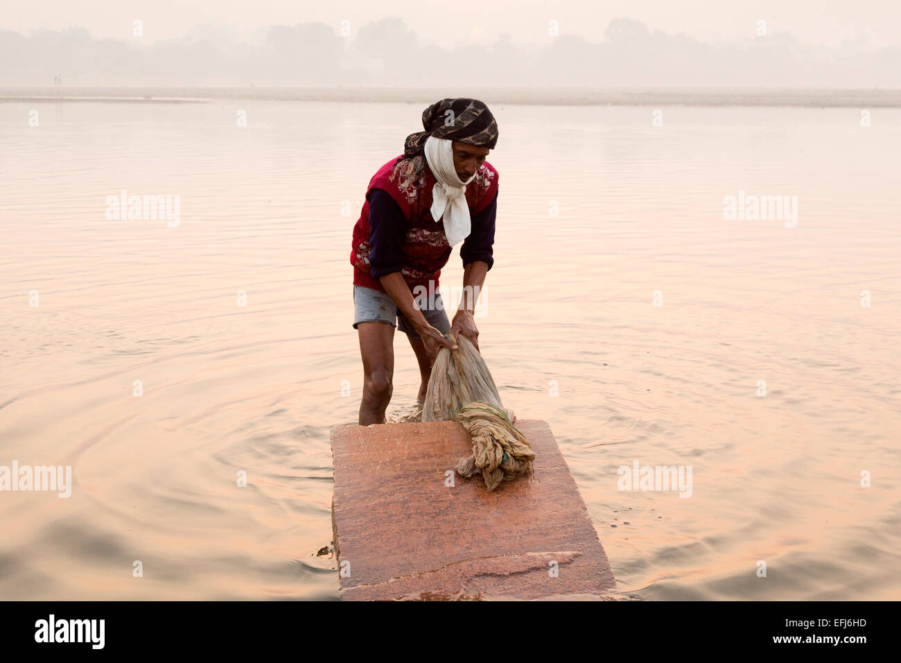 India, Uttar Pradesh, Agra, Dhobi-wallahs at sunrise on Yamuna River ...