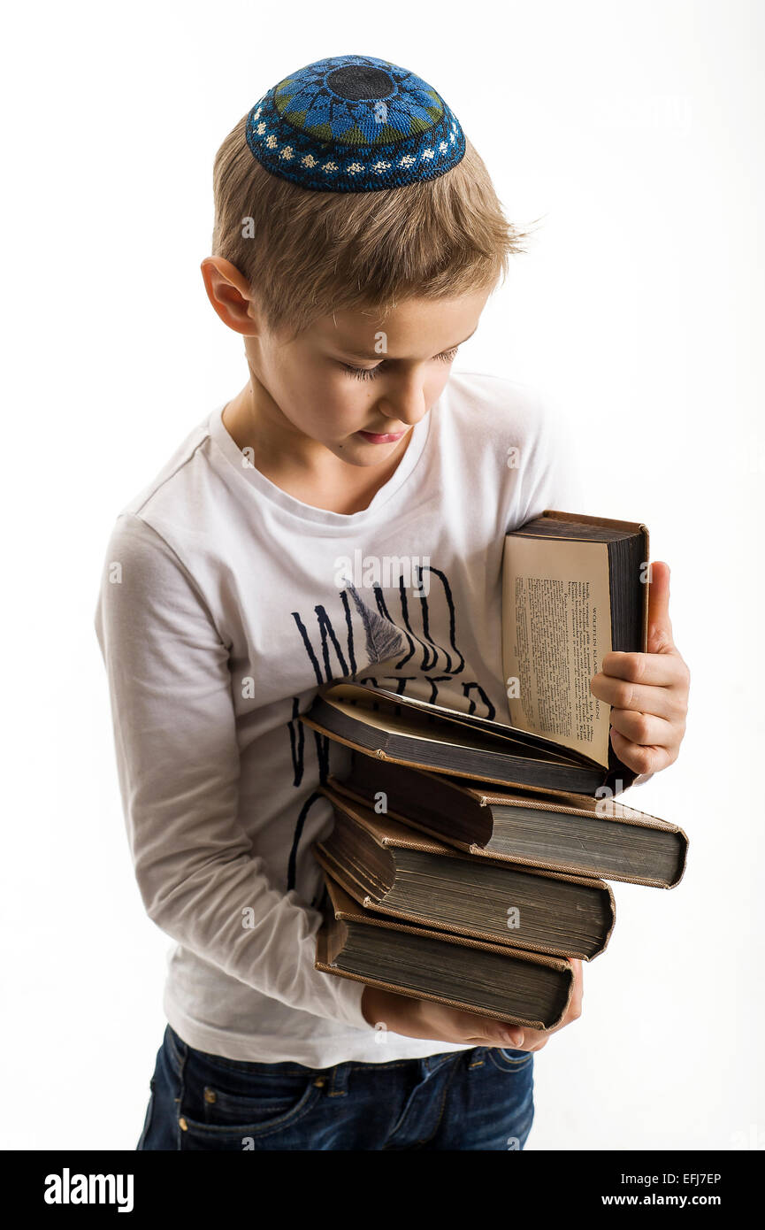studio portrait of white boy with Jewish kipa or yarmulke and books ...